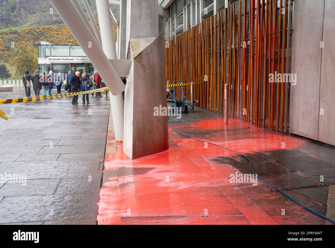 Workmen clean up red paint that was thrown by climate activists outside ...
