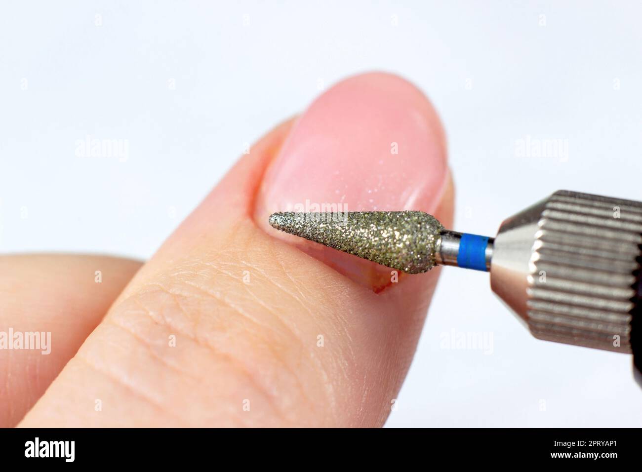 Woman hands making self manicure removing pink gel nail polish at home ...