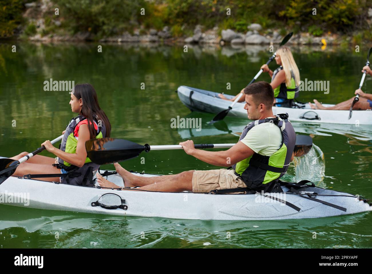 A group of friends enjoying having fun and kayaking while exploring the ...