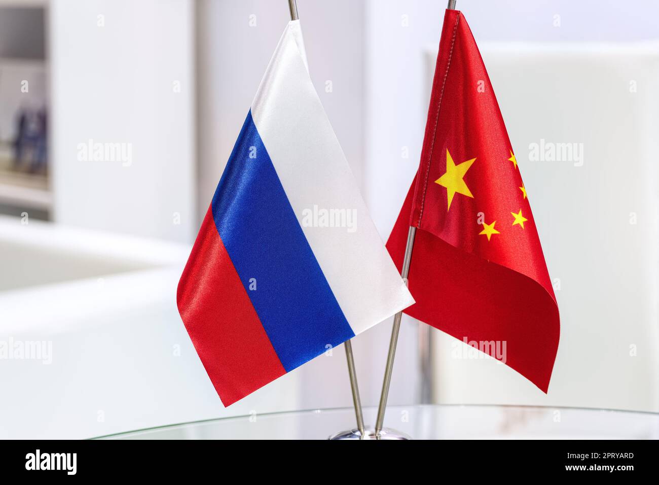 Russian and Chinese flags on glass table in meeting room. The concept ...