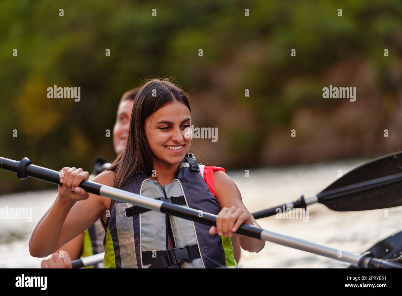 A young couple enjoying an idyllic kayak ride in the middle of a ...