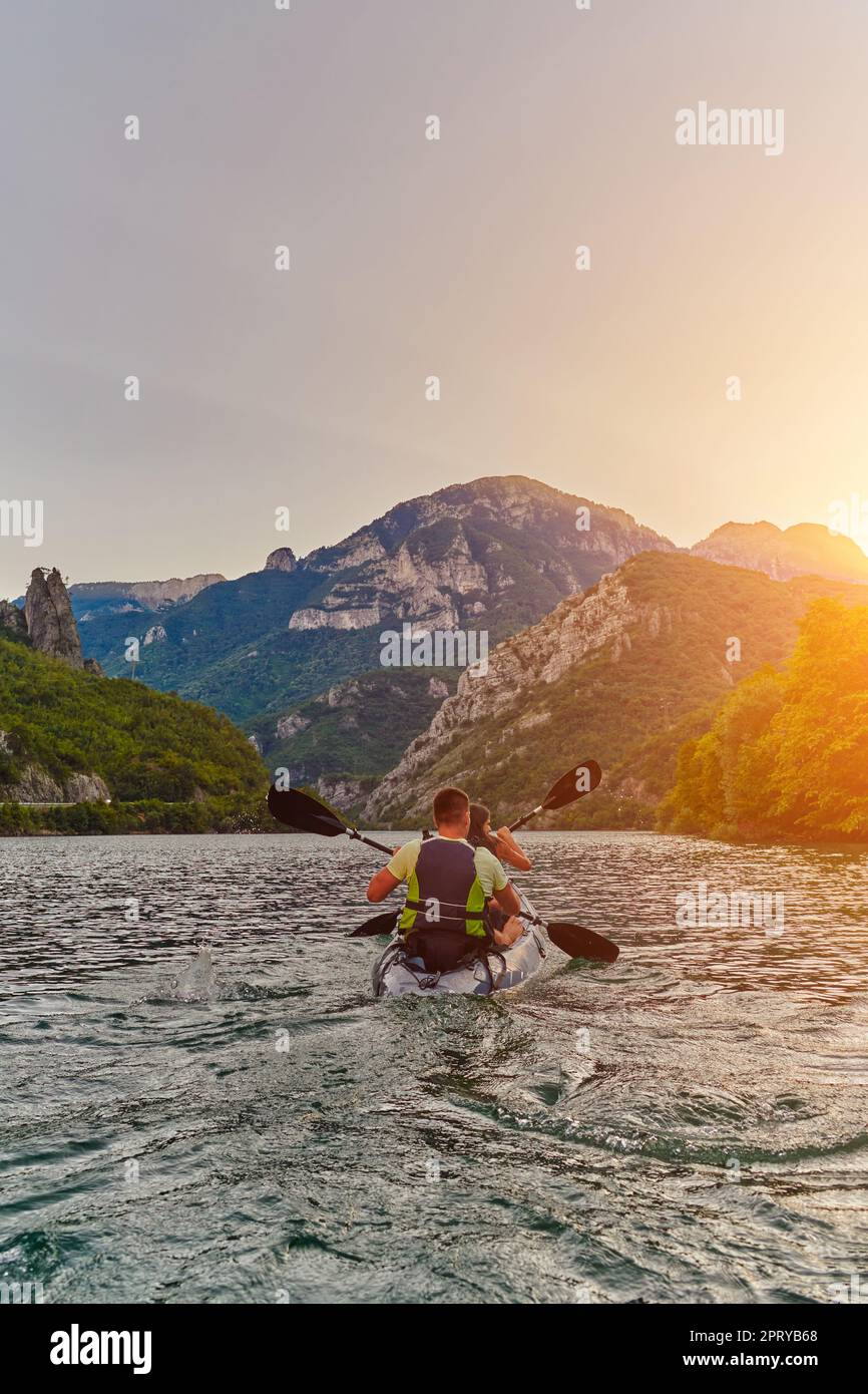 A young couple enjoying an idyllic kayak ride in the middle of a ...