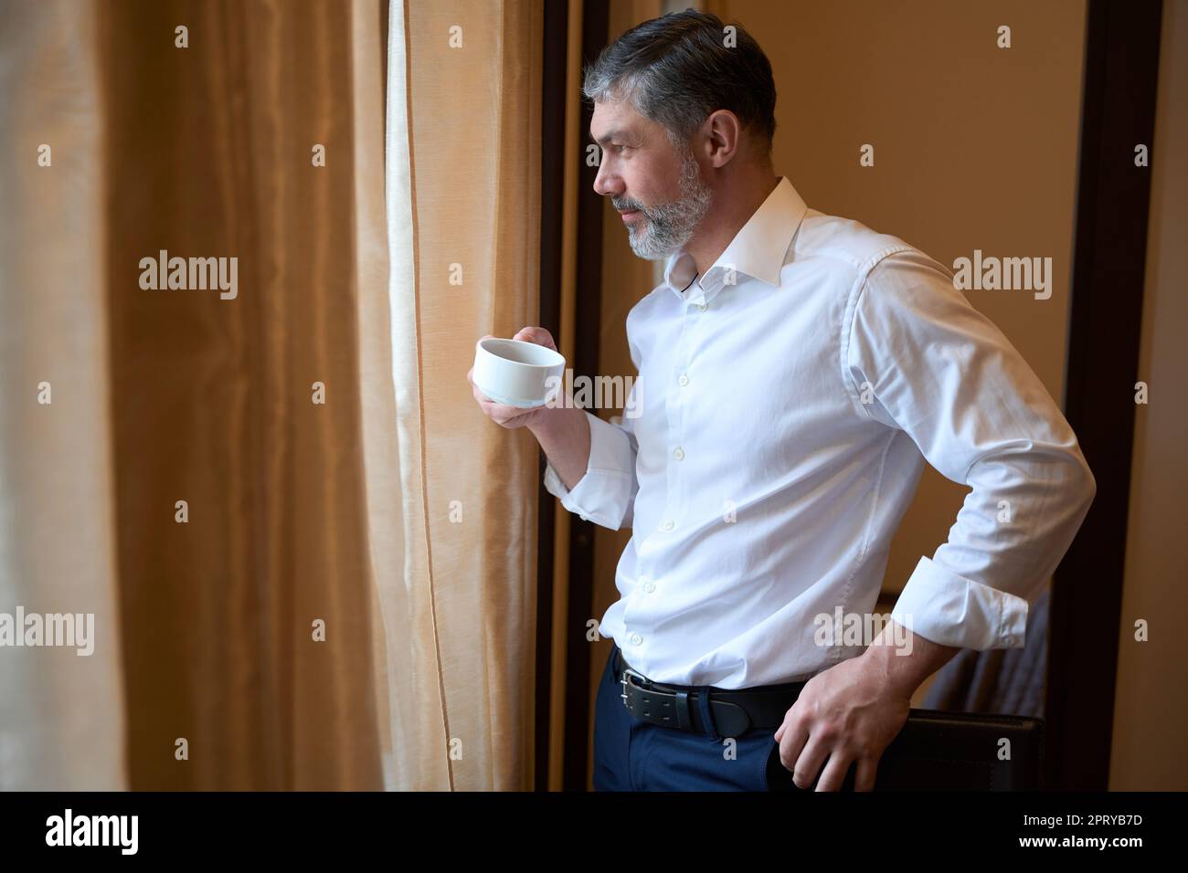 Adult male drinking tea near the window Stock Photo - Alamy