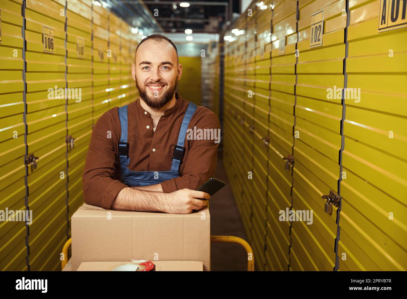 Handsome man leaning on boxes in the warehouse Stock Photo - Alamy