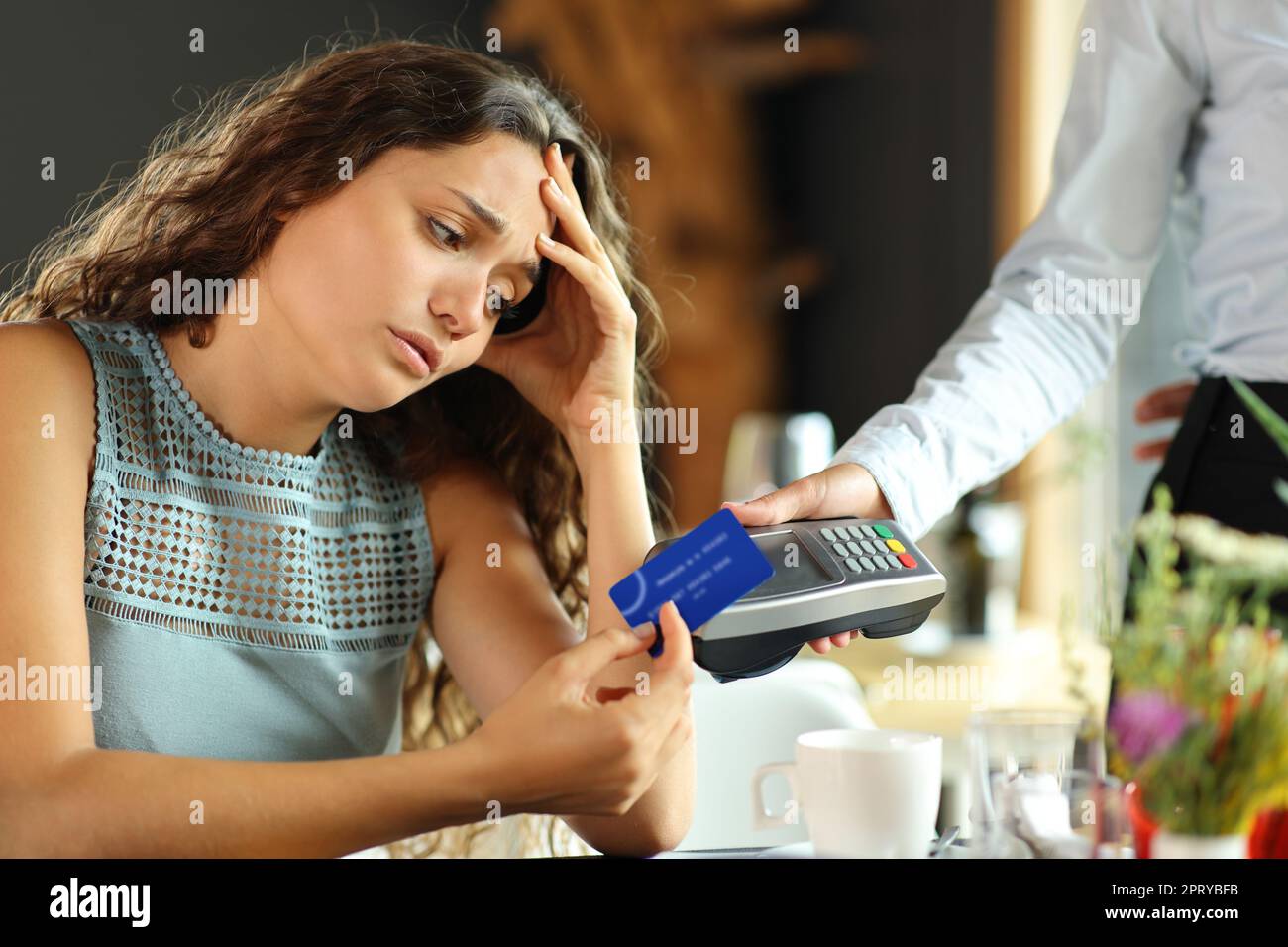 Worried customer paying expensive bill with credit card in a restaurant ...