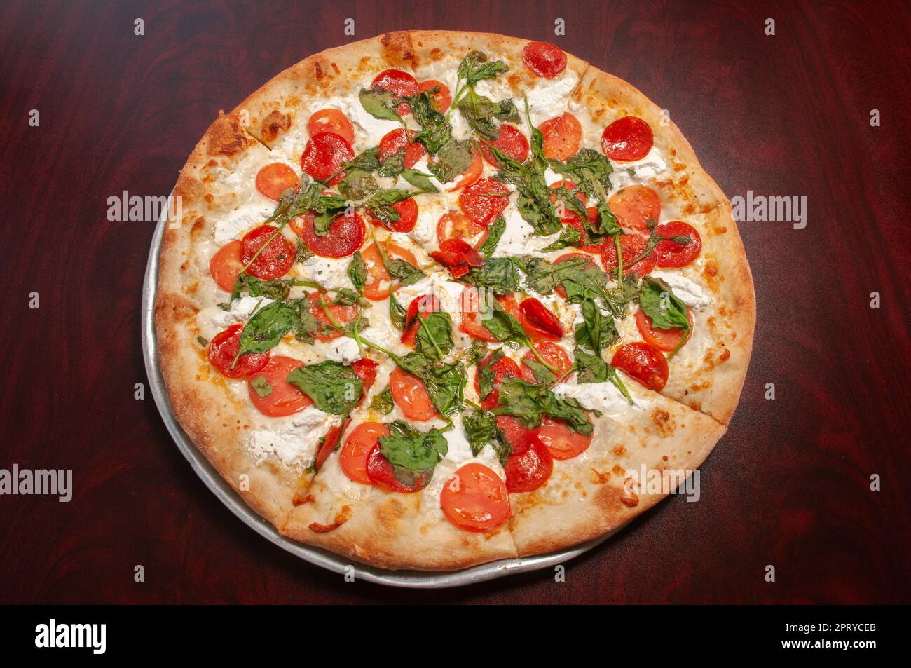 Delicious and delectable spinach and tomato pizza pie Stock Photo - Alamy