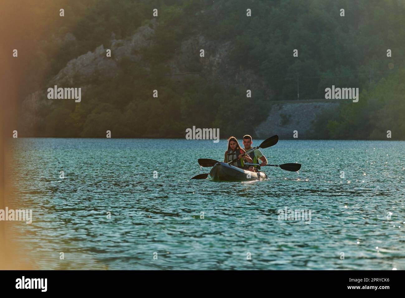 A young couple enjoying an idyllic kayak ride in the middle of a ...