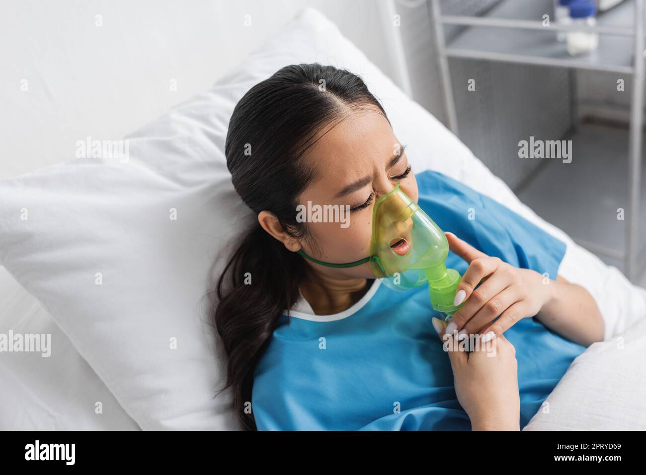 high angle view of worried asian woman with closed eyes breathing in ...