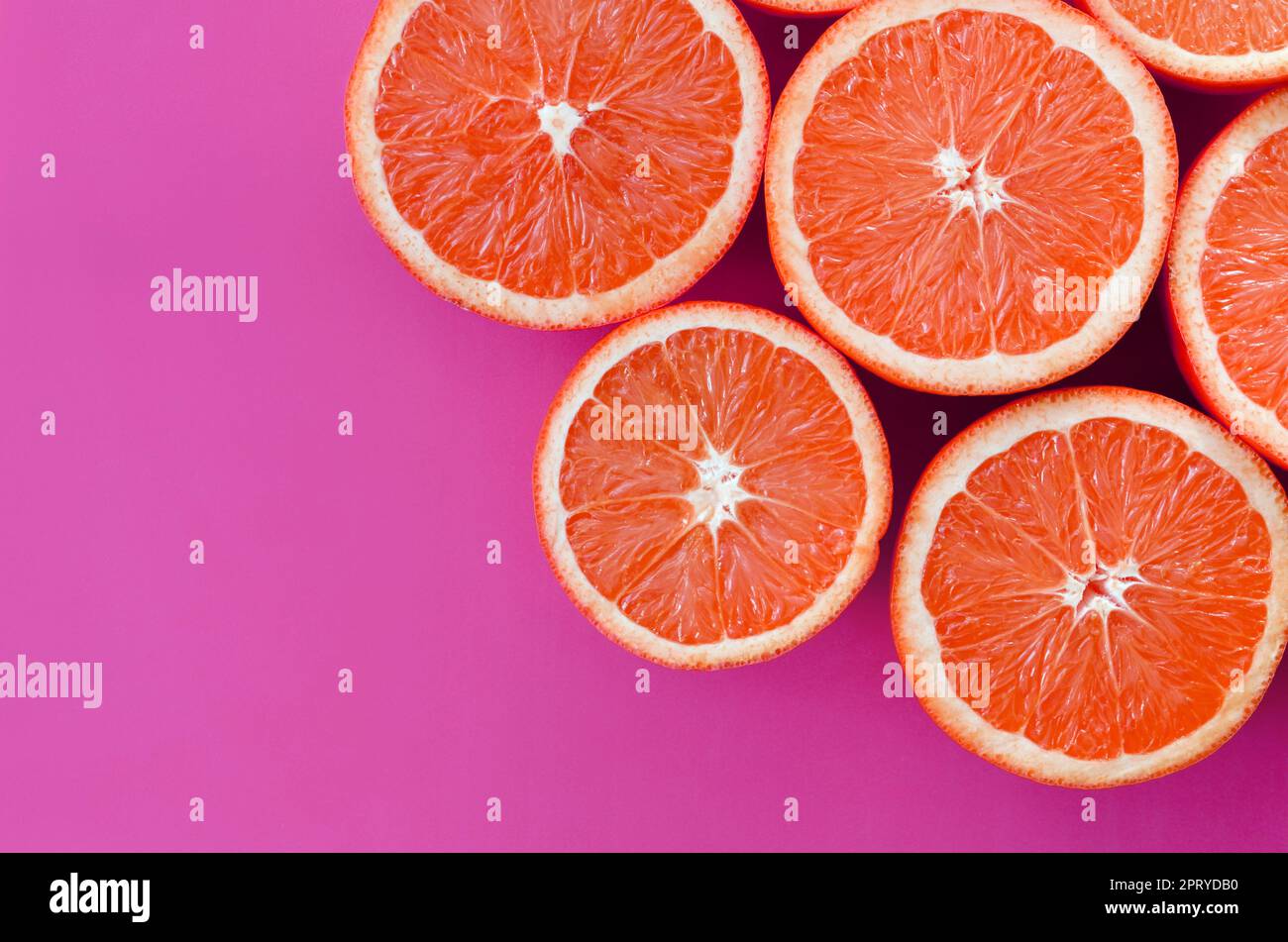 Top view of a several grapefruit slices on bright background in purple ...