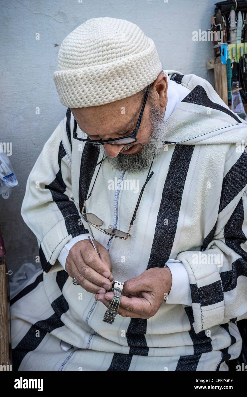Watchmaker fixing the mechanism of a wristwatch with a precision tool ...
