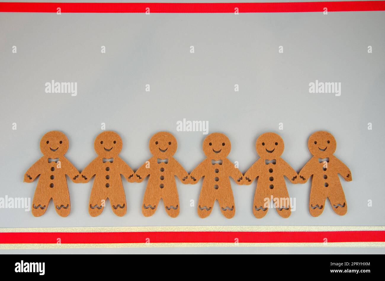 Gingerbread men in a line, red and gold ribbon Stock Photo - Alamy
