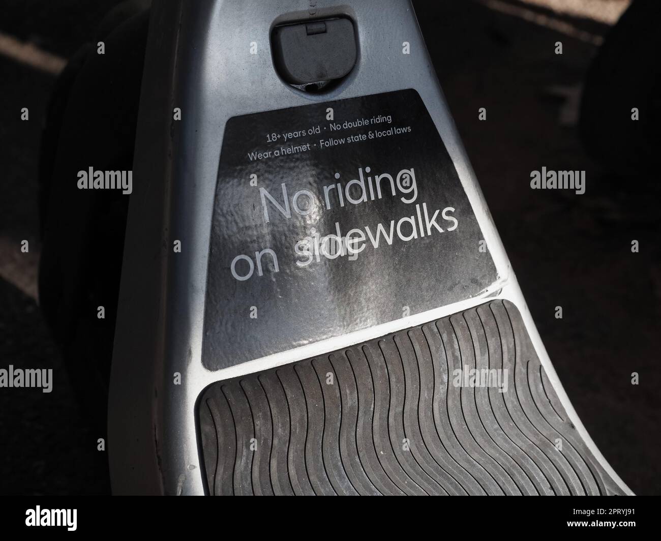 Warning label on escooter, no riding on sidewalks, wear a helmet follow ...