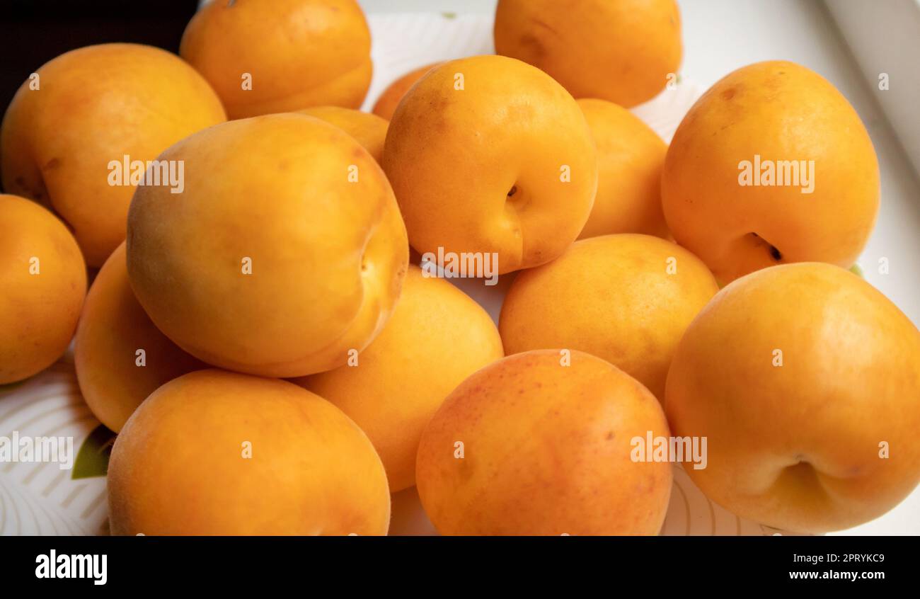 A bunch of fresh ripe apricots on a plate, close-up, shallow depth of ...