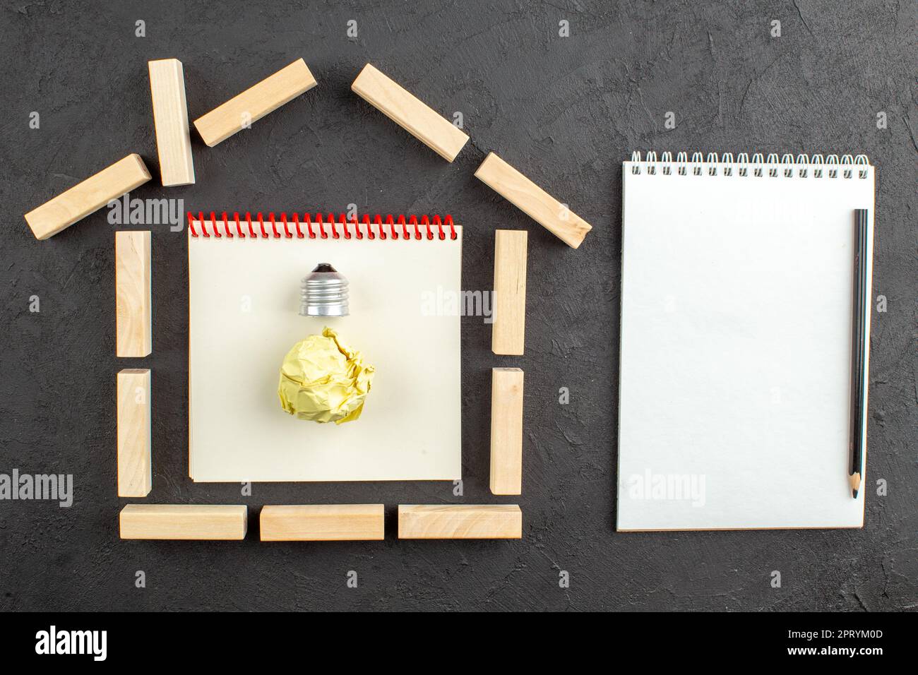 top view house shaped wood blocks idealight bulb on notepad black ...