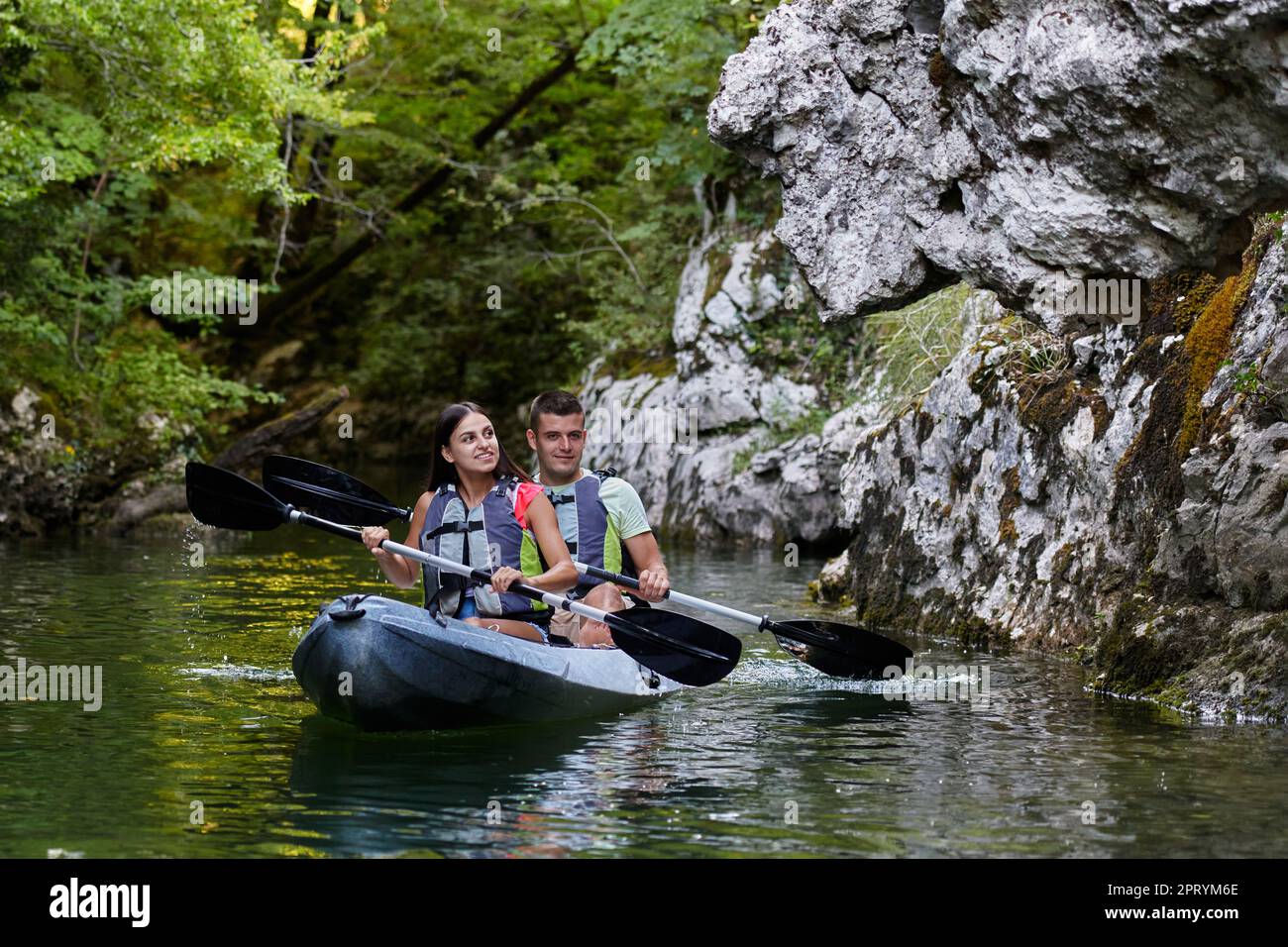 A young couple enjoying an idyllic kayak ride in the middle of a ...
