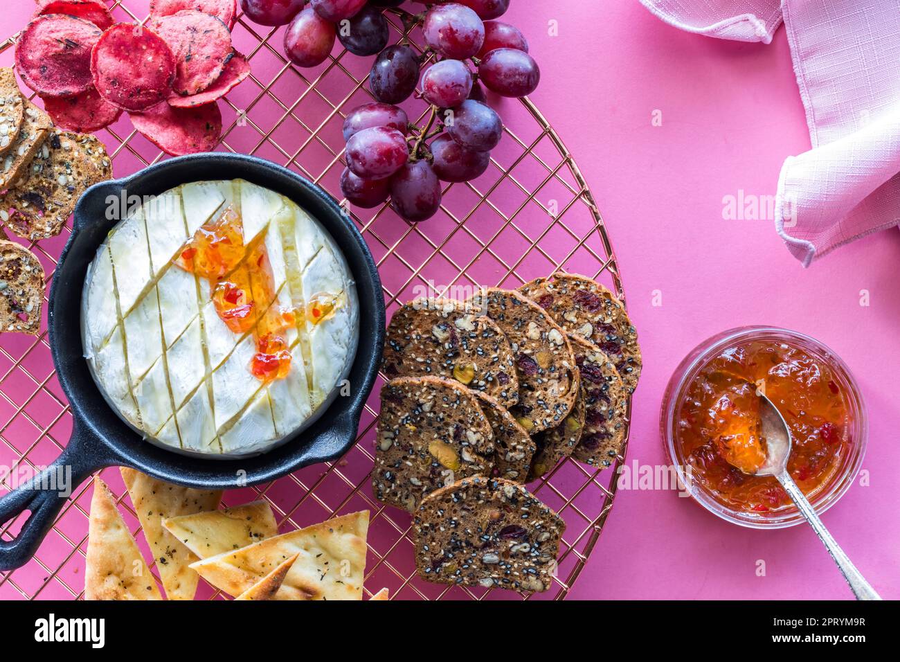 baked brie cheese in a cast iron skillet surrounded by assorted dippers ...