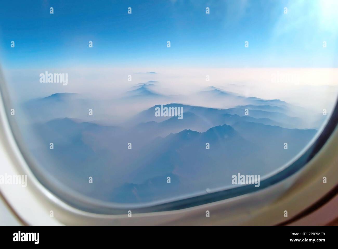 The arial view from the plane window on the mountain ridge, clouds and ...