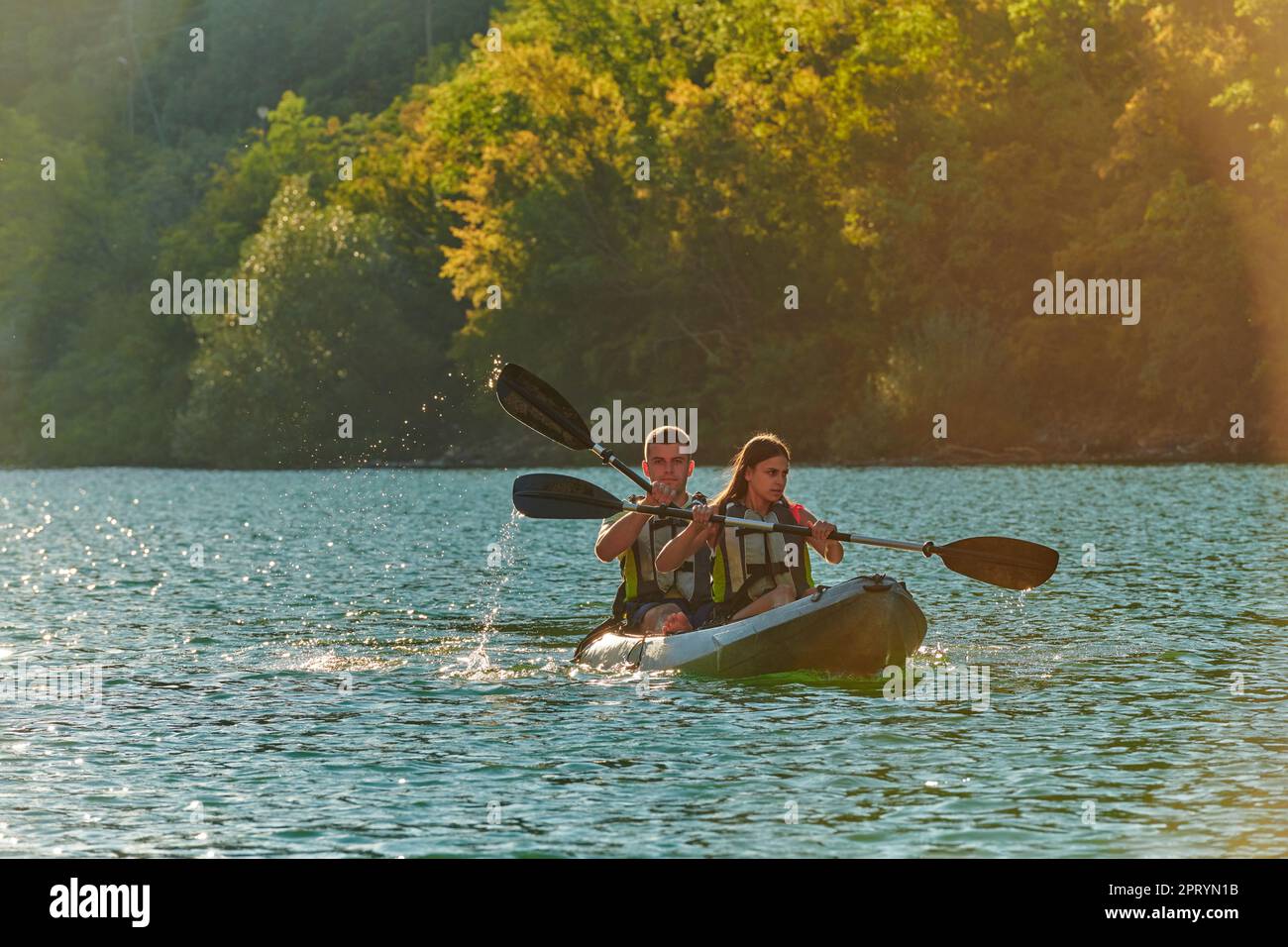 A young couple enjoying an idyllic kayak ride in the middle of a ...