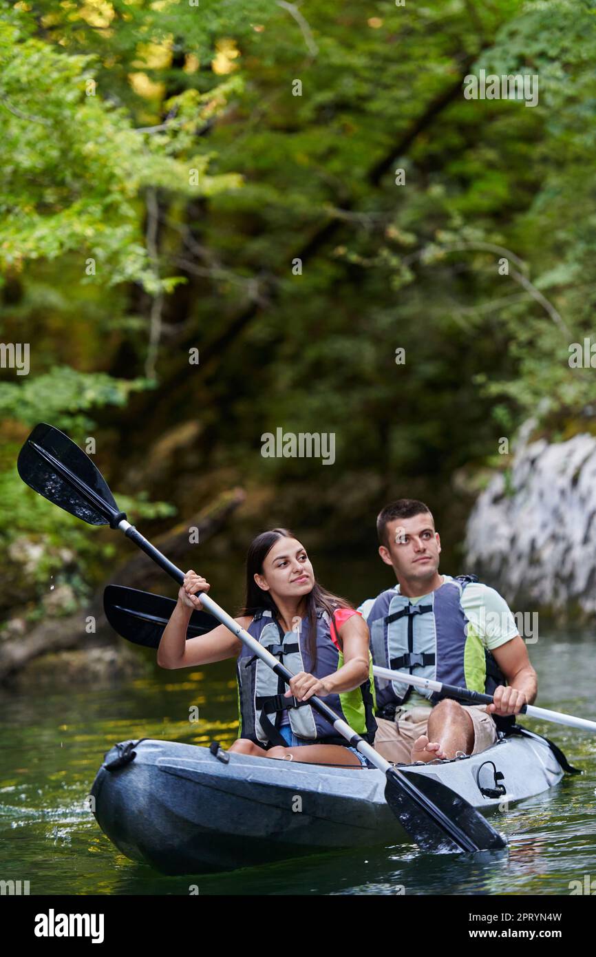 A young couple enjoying an idyllic kayak ride in the middle of a ...