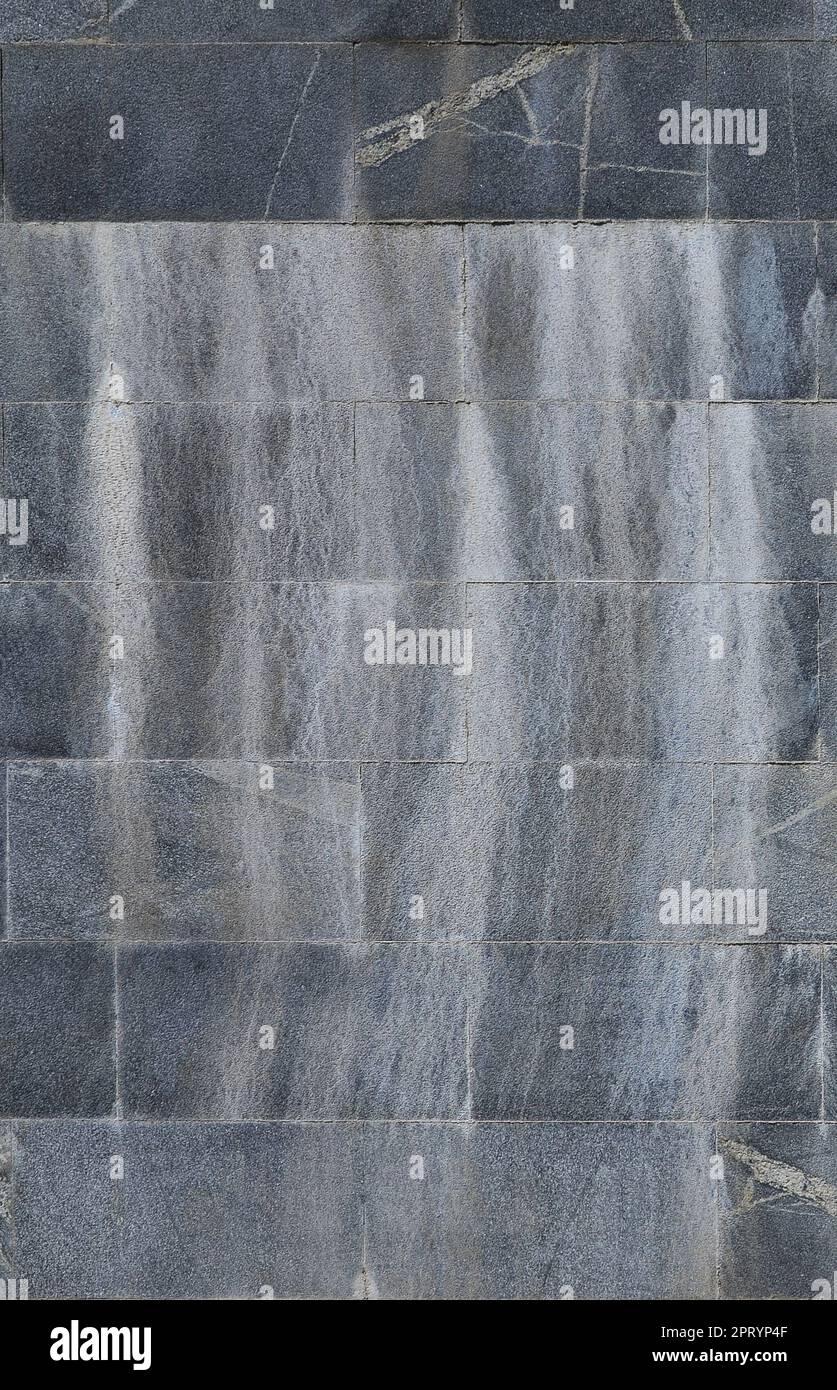 The texture of a wall of large granite tiles that are covered with ...