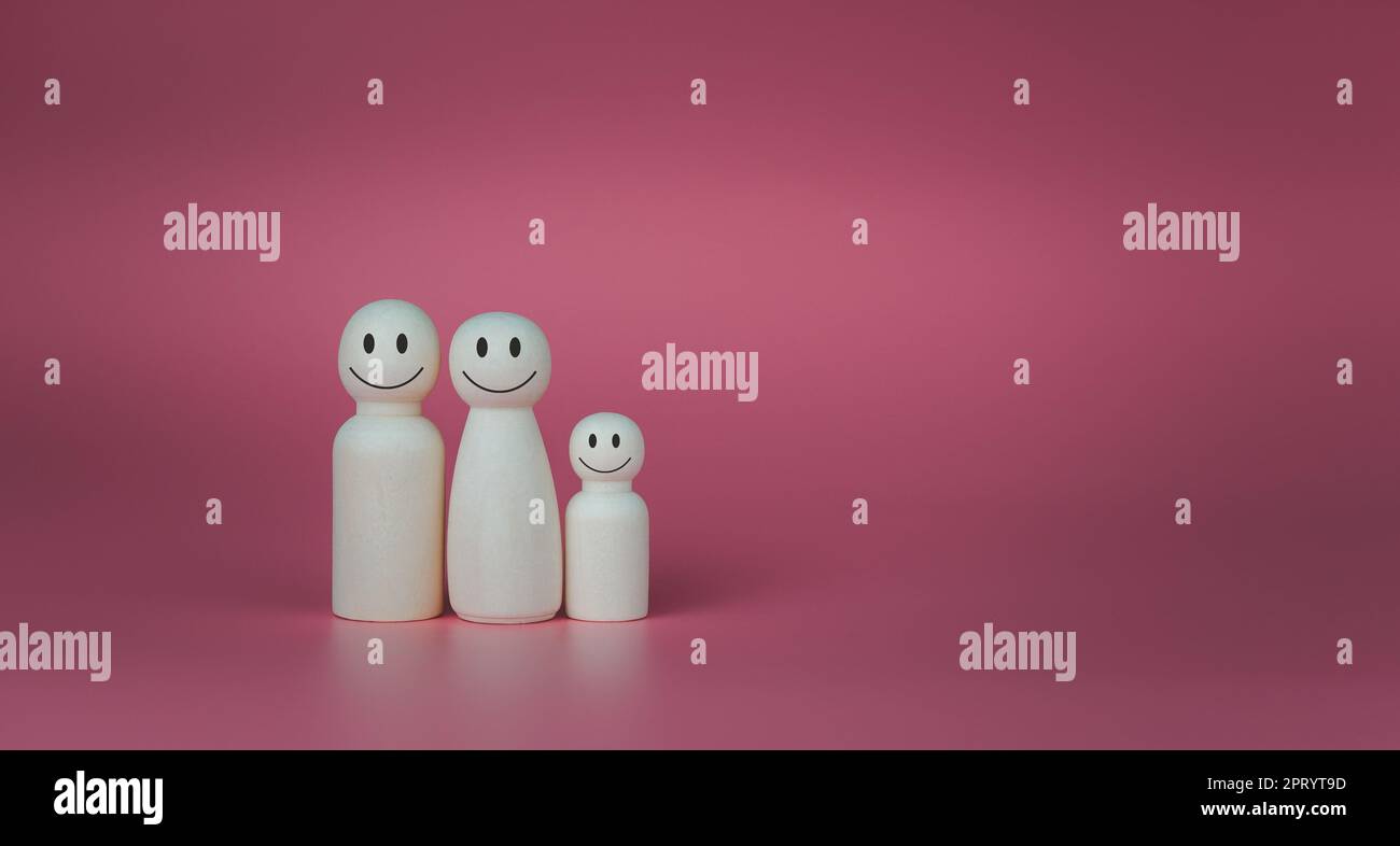 Happy house concept. Wooden dolls stand lined up against a pink ...