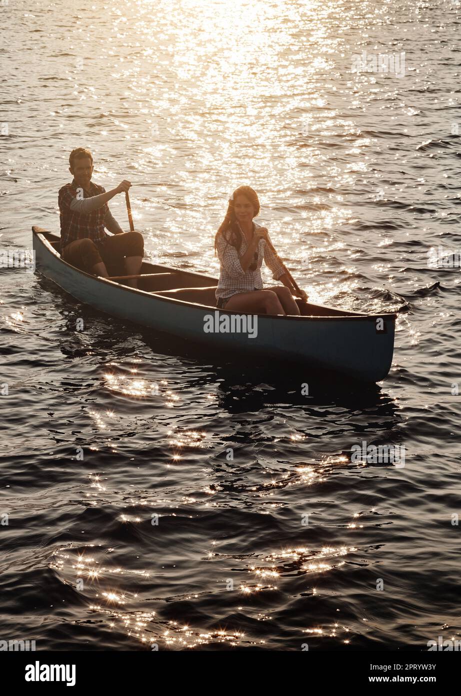 Following the course of adventure. a young couple rowing a boat out on ...