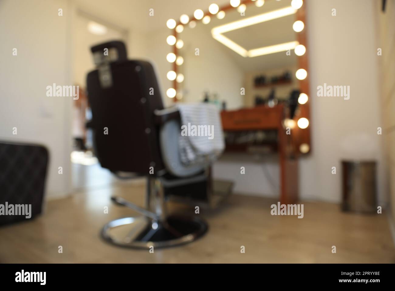 Blurred view of stylish barbershop interior with hairdresser workplace ...
