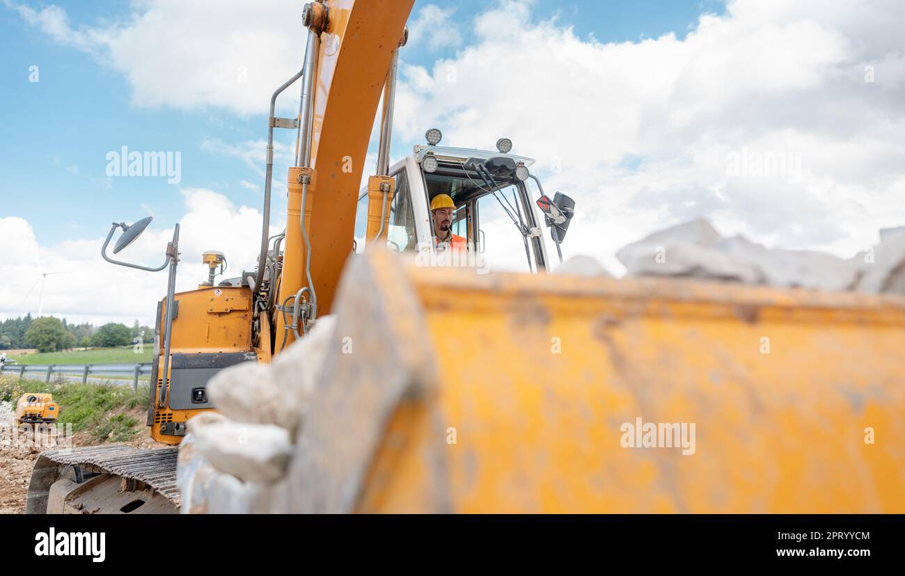 Construction worker operating the crawler excavator in underground ...