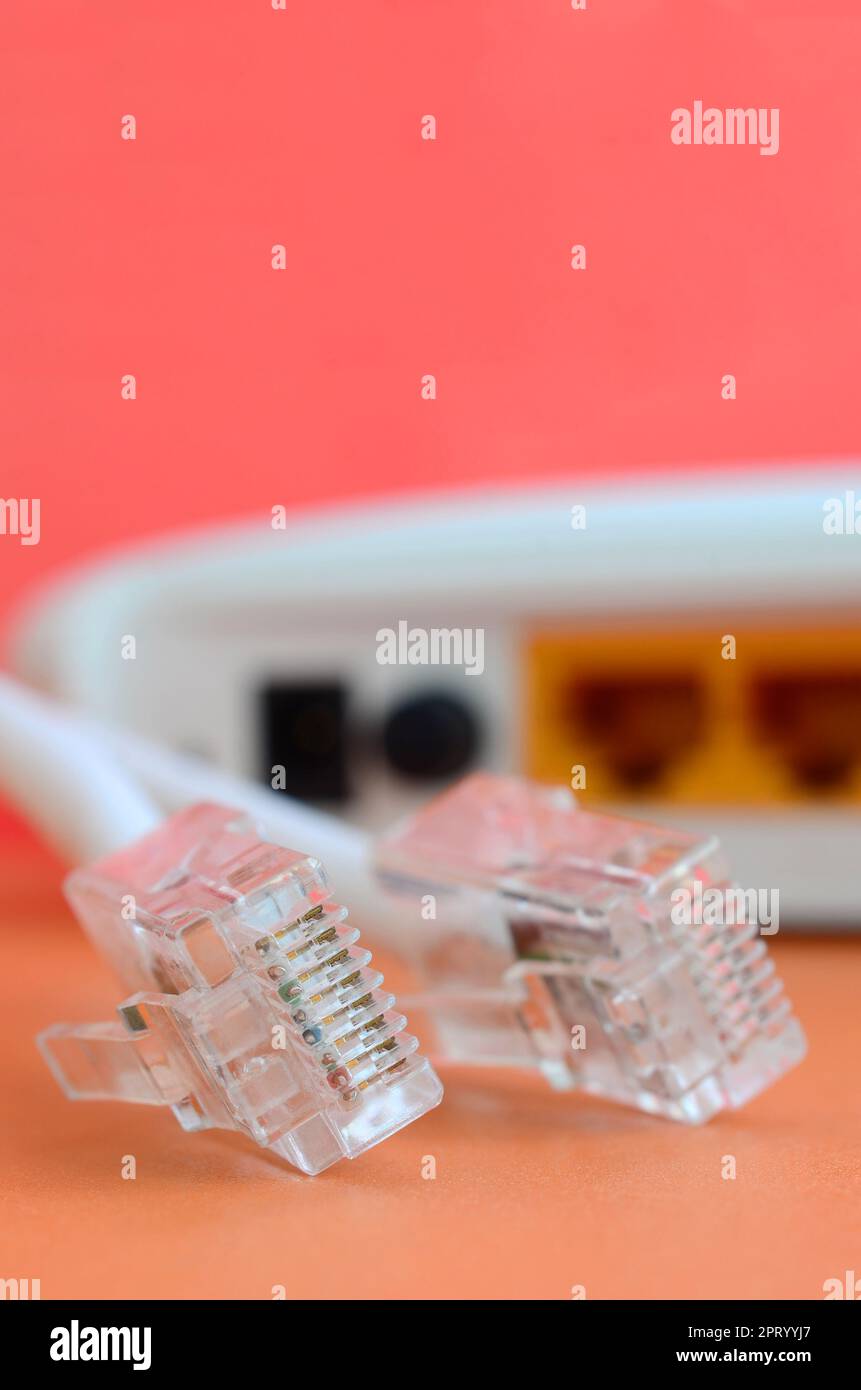 Internet router and Internet cable plugs lie on a bright orange ...
