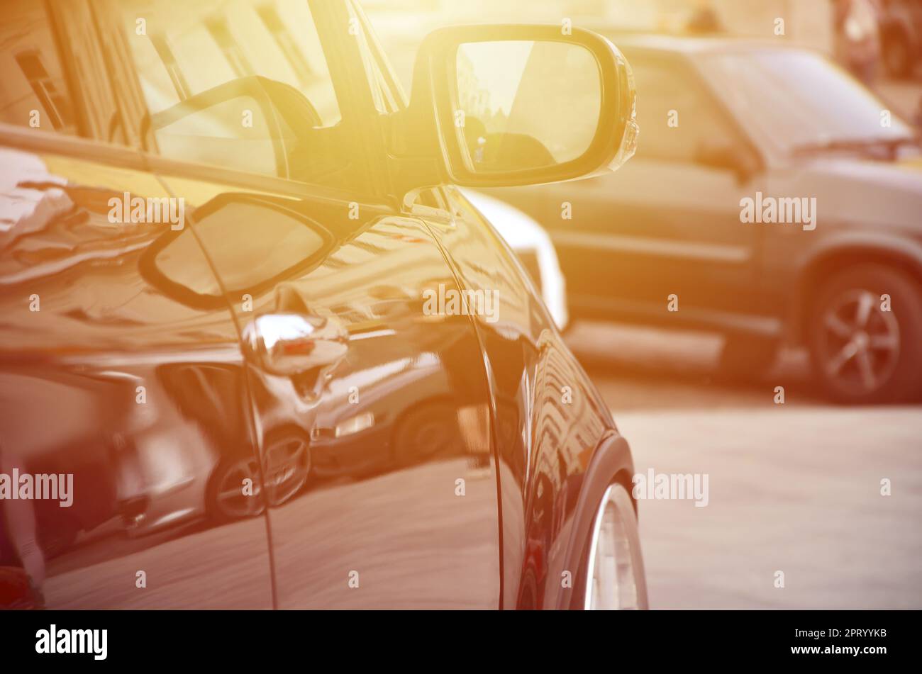 Diagonal view of a black glossy car with white wheels, which stands on ...