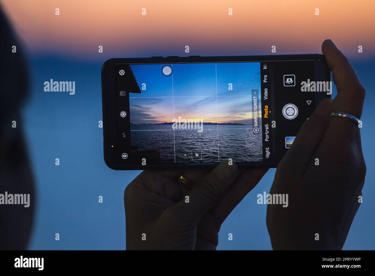 Woman shooting sunset mobile phone hi-res stock photography and images ...
