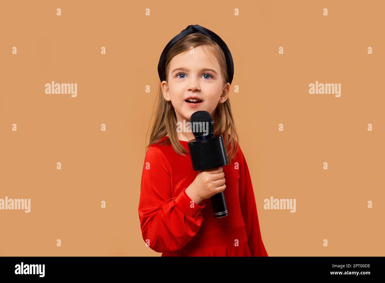 Artistic girl in red dress singing in karaoke microphone Stock Photo ...