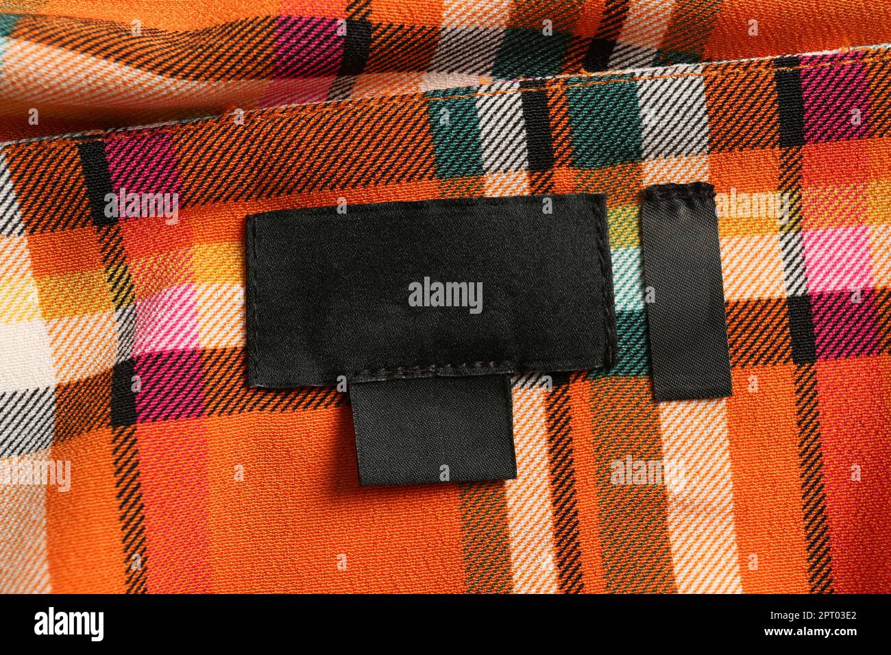 Blank clothing label on checkered apparel, top view Stock Photo - Alamy