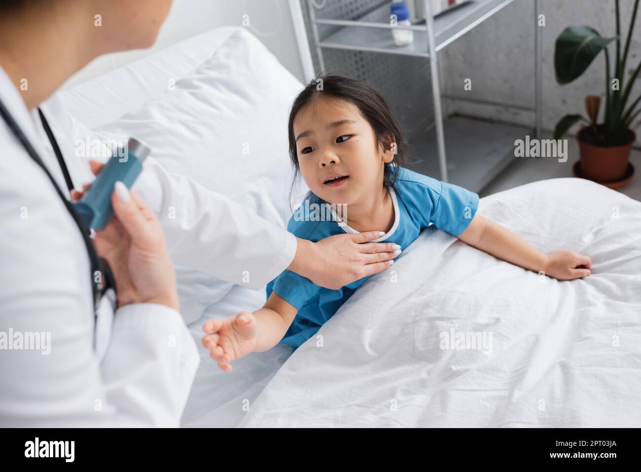 curious asian girl with outstretched hand reaching doctor with inhaler ...