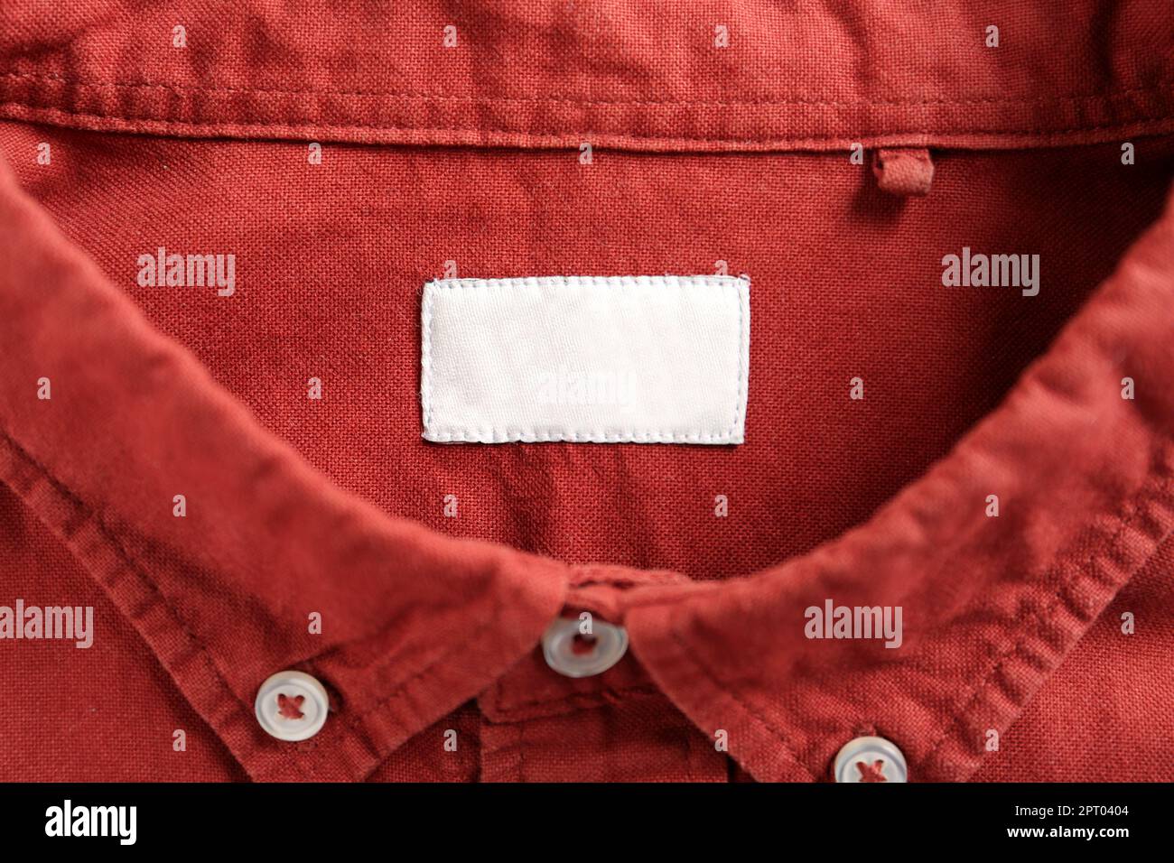 Blank clothing label on red shirt, top view Stock Photo - Alamy