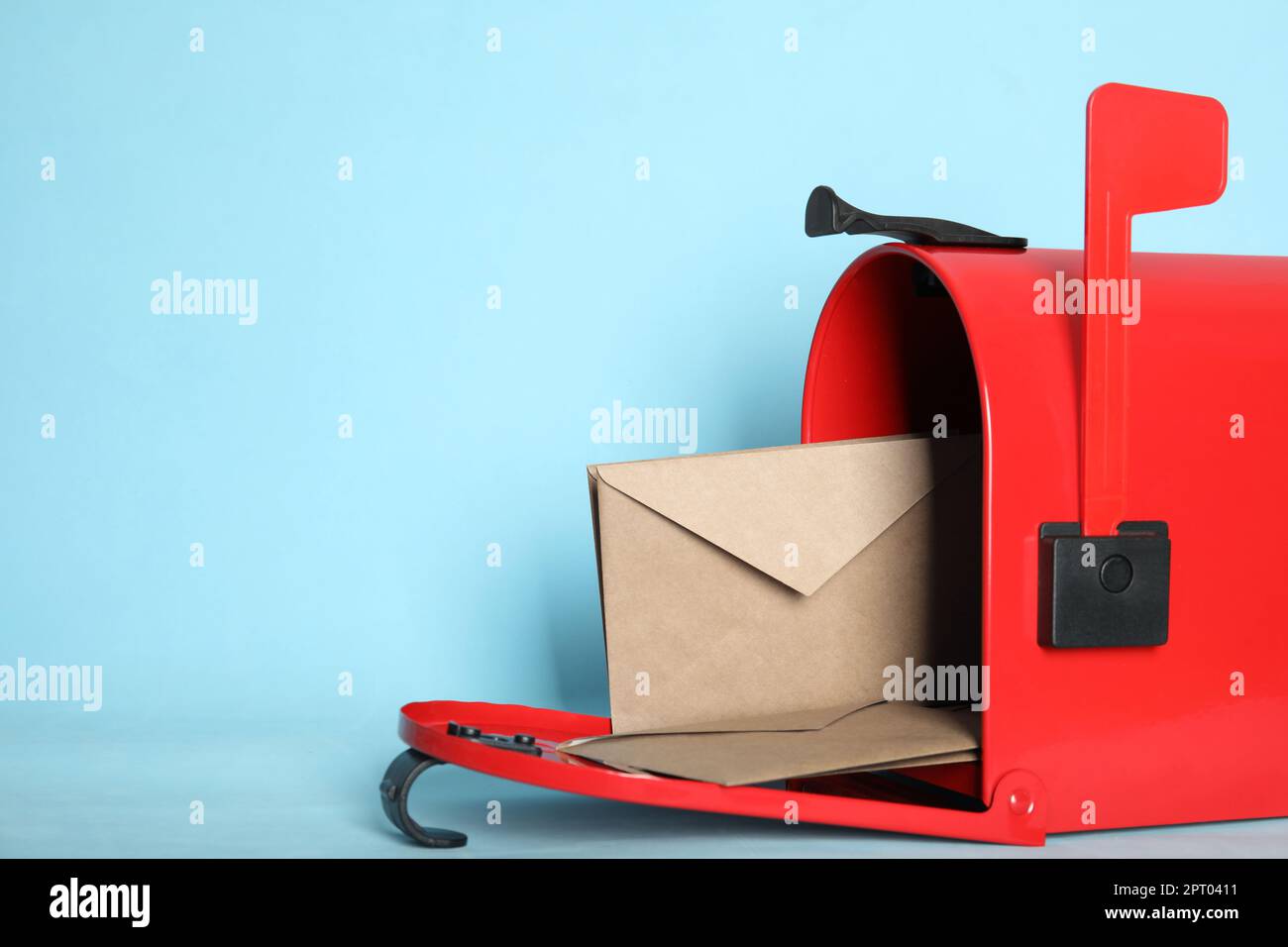 Open red letter box with envelopes on turquoise background, closeup ...
