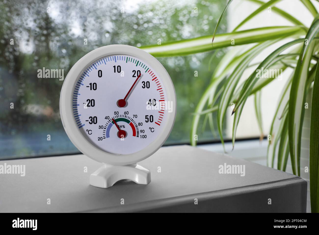 Round mechanical hygrometer on book near window Stock Photo - Alamy