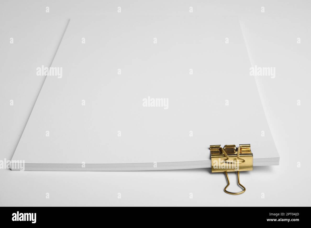Sheets of paper with clip on white background Stock Photo - Alamy