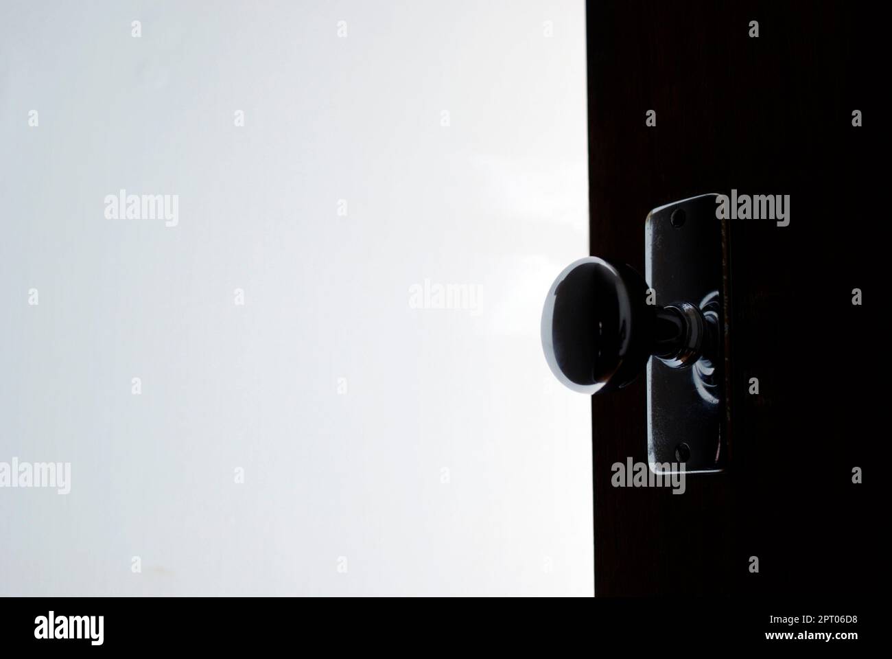 High contrast conceptual image of door handle close up opening door to ...