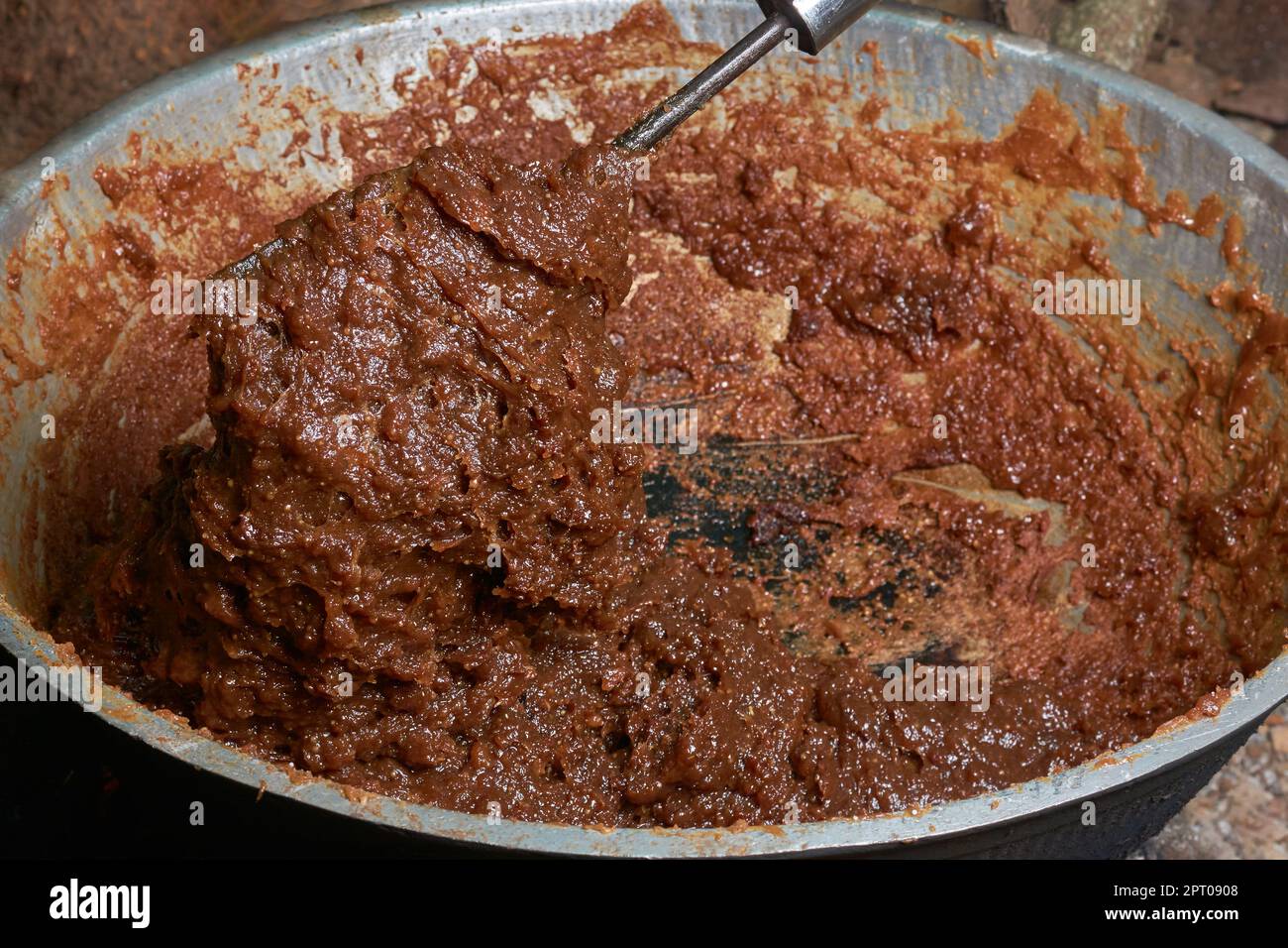 making dodol, close-up view of cooking dark sweet candy made from ...