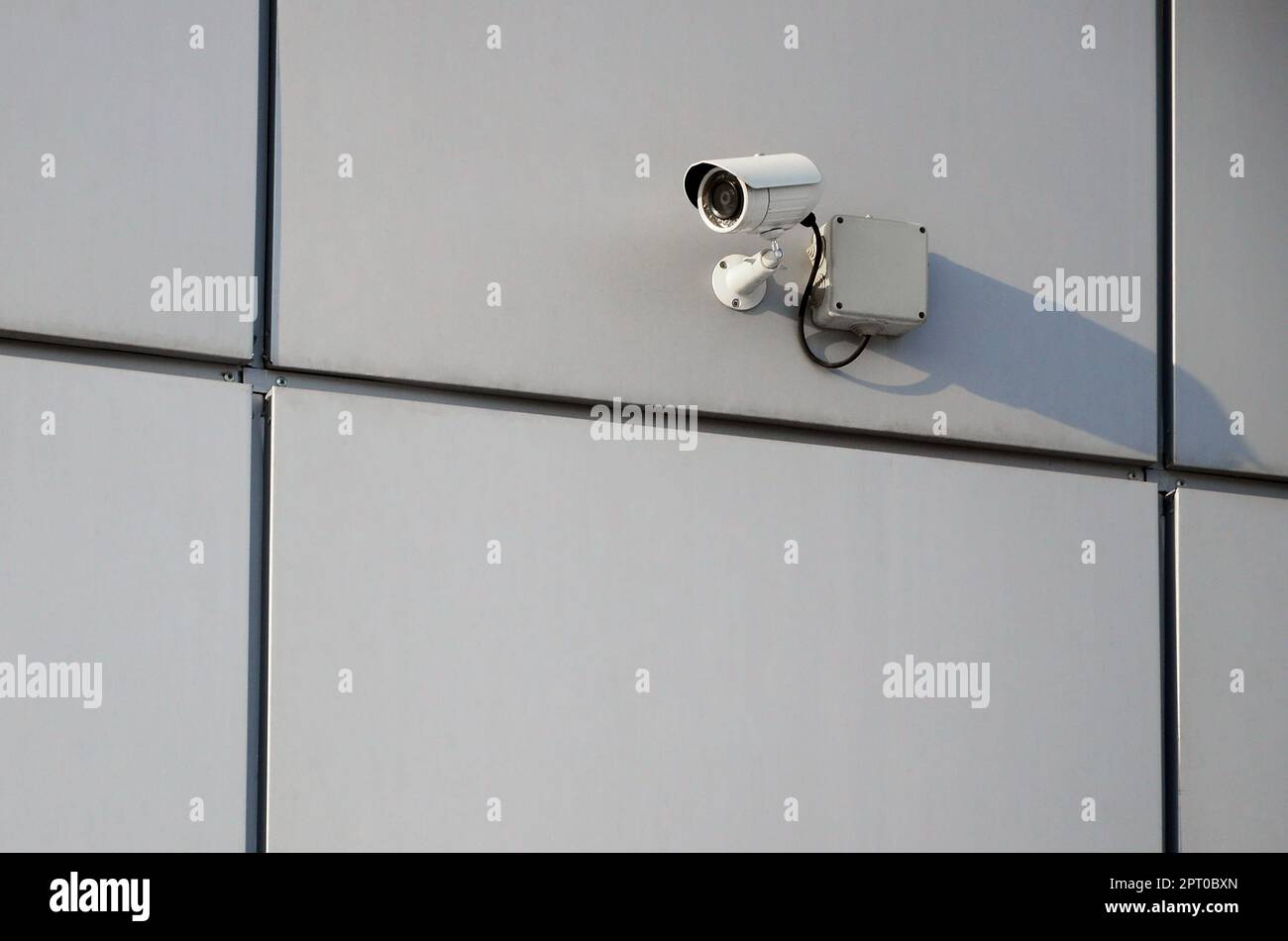 White surveillance camera built into the metal wall of the office ...