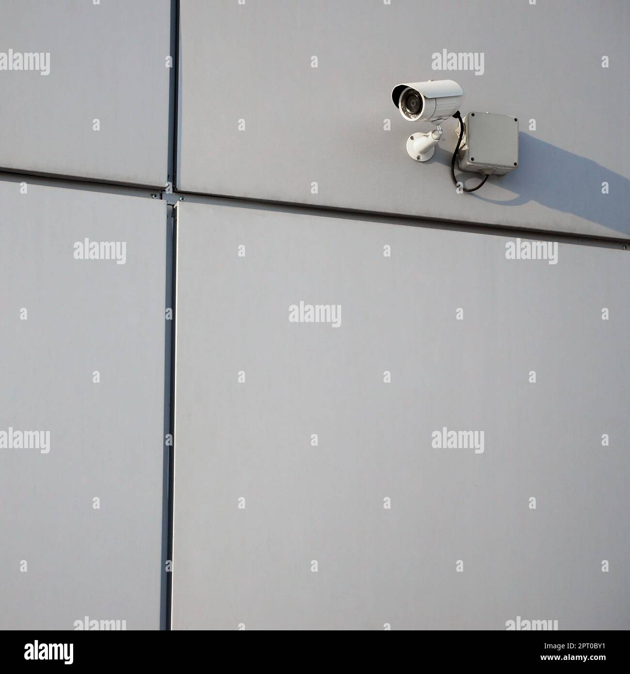 White surveillance camera built into the metal wall of the office ...