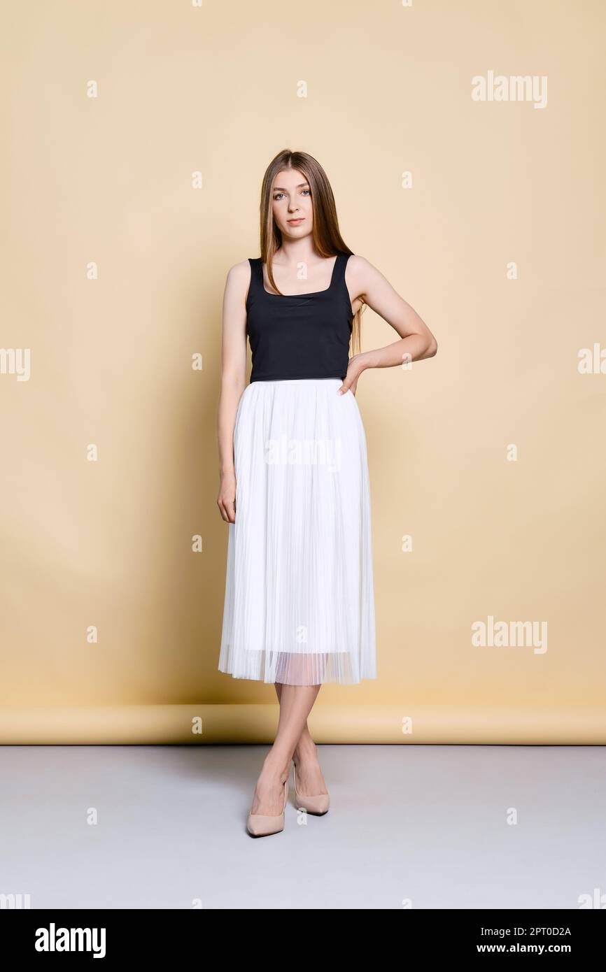 Full length portrait of pretty young woman in black tank top and white ...