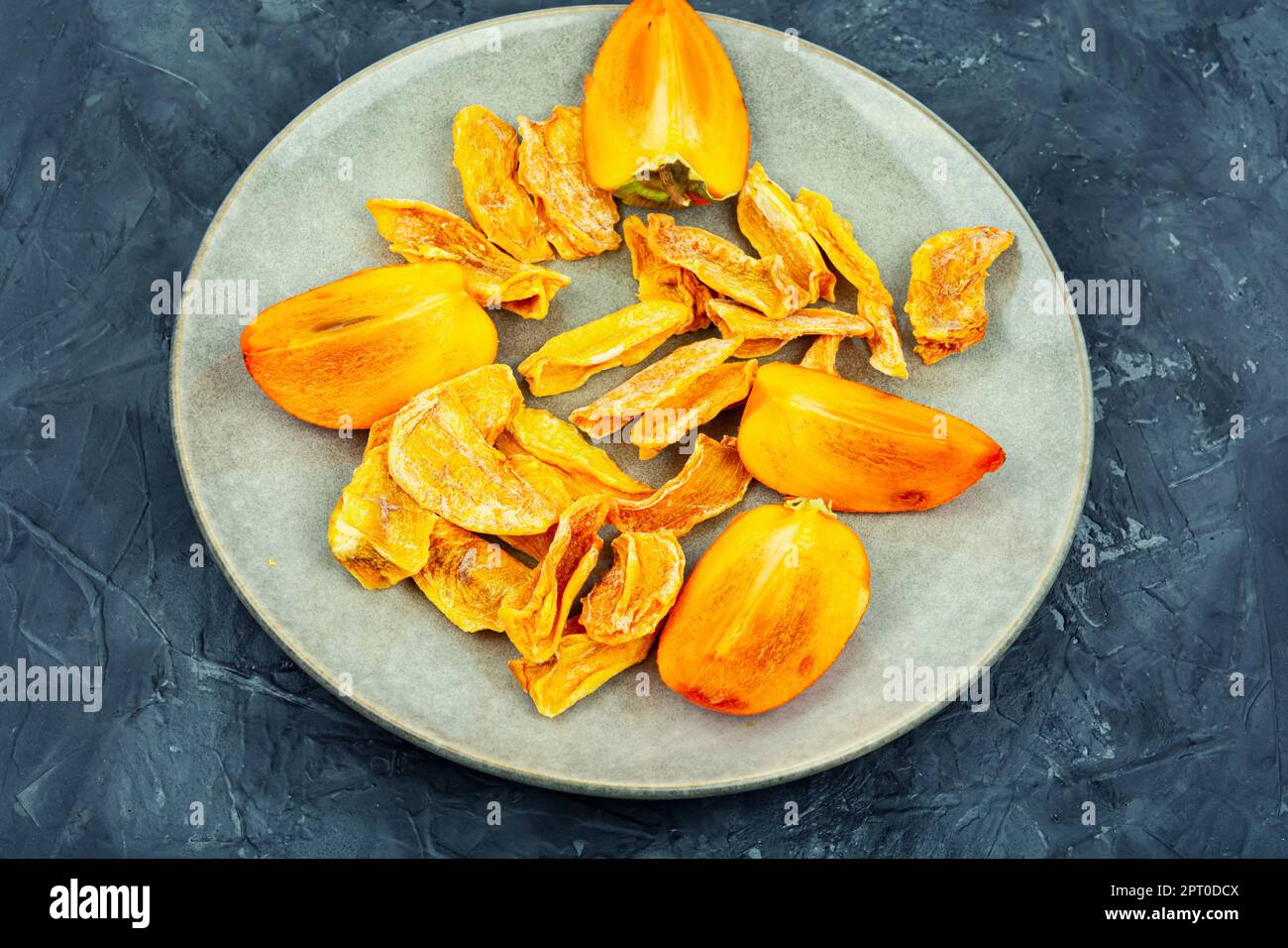 Sweet dried persimmon on the plate. Healthy vegan snacks Stock Photo ...