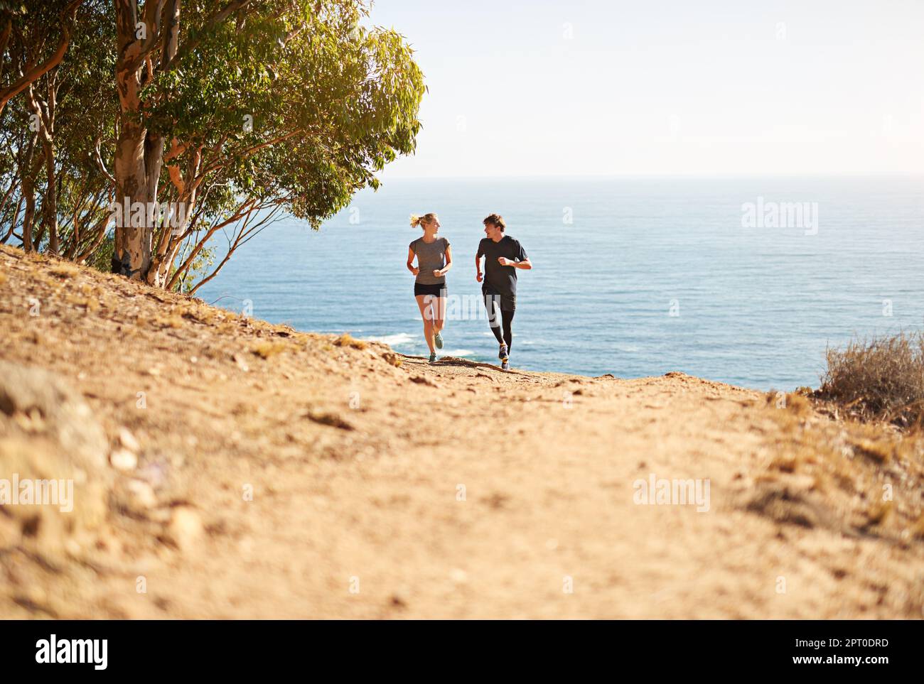 Taking the scenic route to fitness. a young couple trail running Stock ...