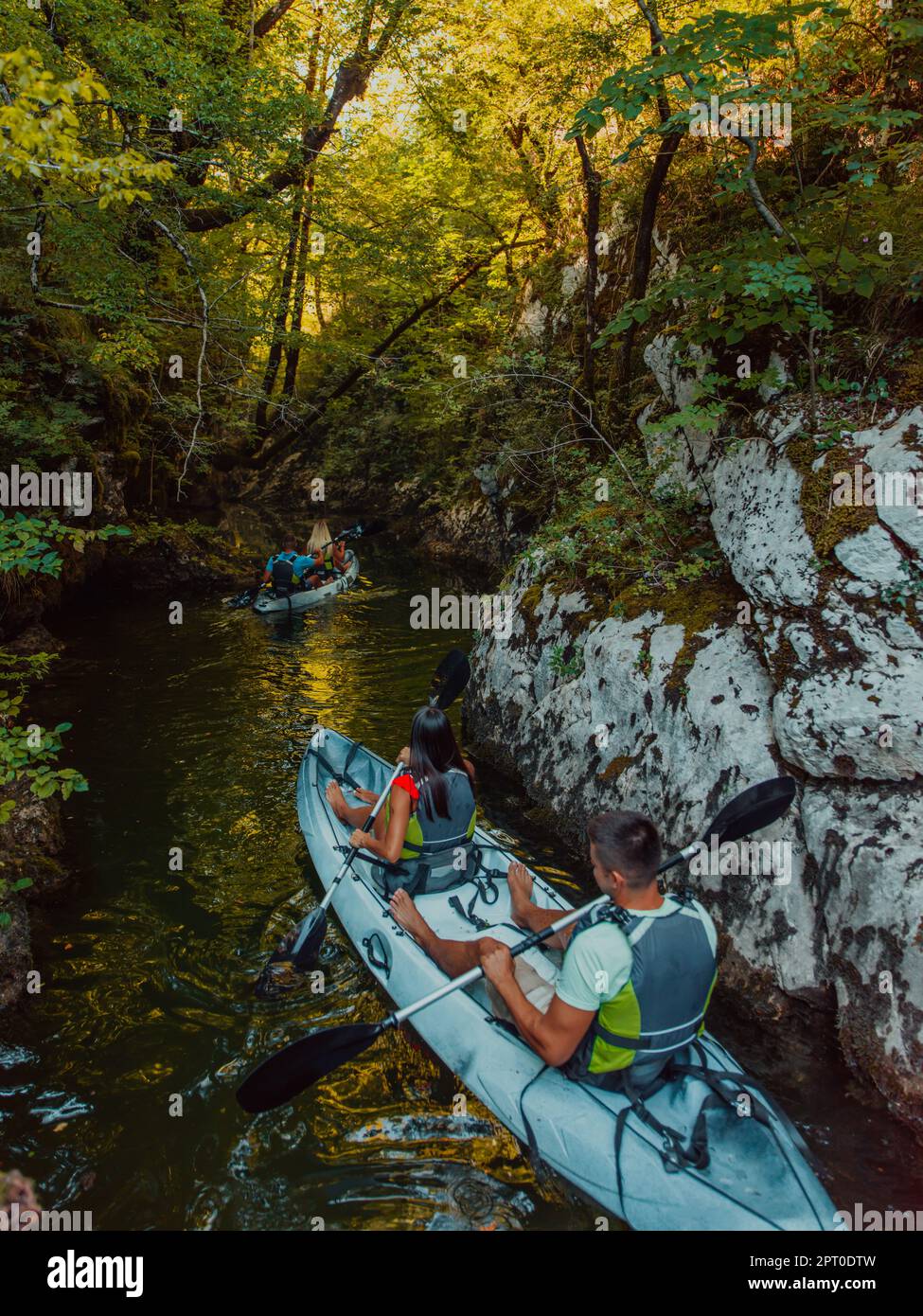 A young couple enjoying an idyllic kayak ride in the middle of a ...