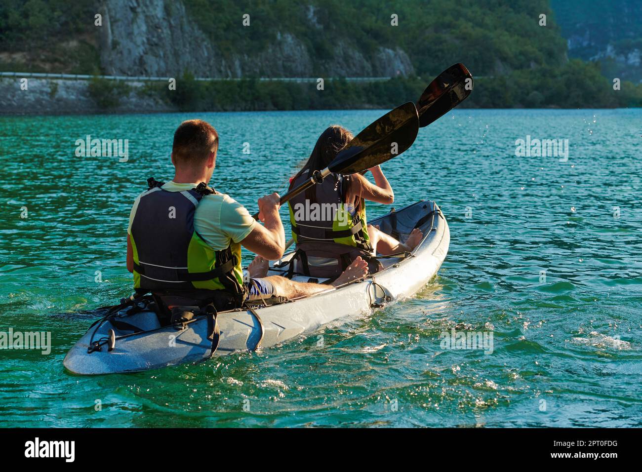 A young couple enjoying an idyllic kayak ride in the middle of a ...