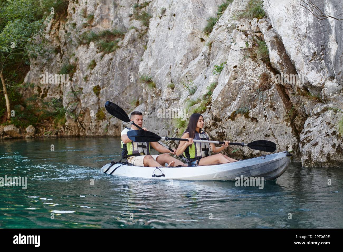 A young couple enjoying an idyllic kayak ride in the middle of a ...