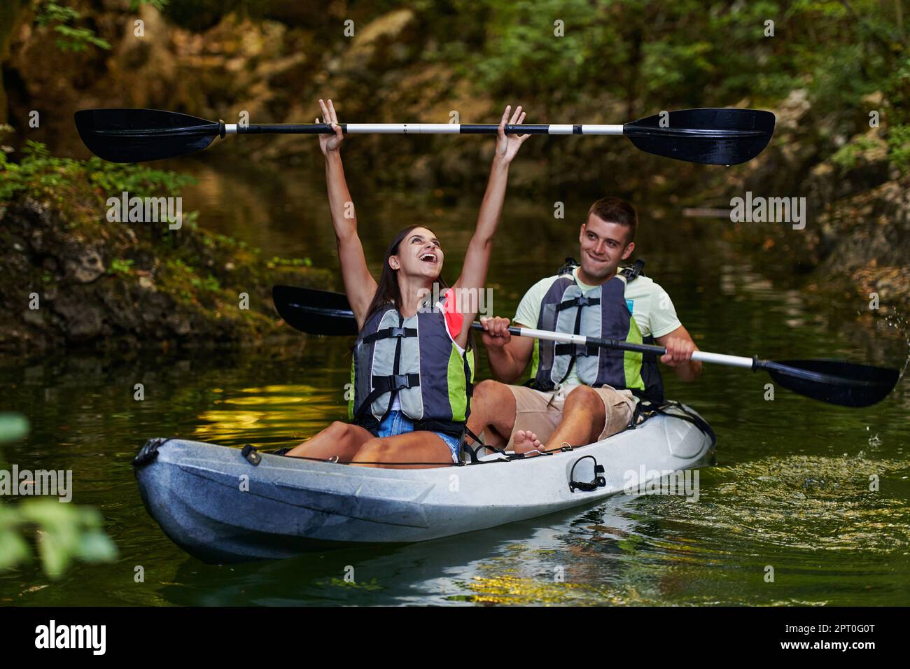 A young couple enjoying an idyllic kayak ride in the middle of a ...