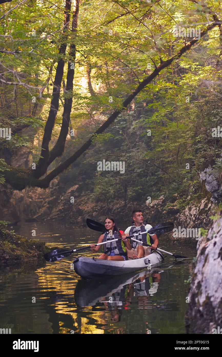 A young couple enjoying an idyllic kayak ride in the middle of a ...
